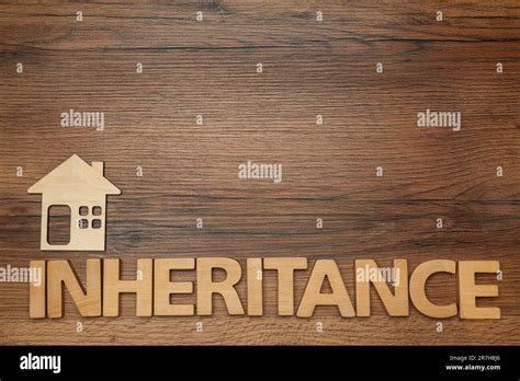 word inheritance made with letters and house model on wooden background