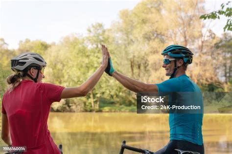 강변에서 서로 하이파이브를 하는 두 명의 사이클리스트 경주용 자전거에 대한 스톡 사진 및 기타 이미지 경주용 자전거 커플 20 24세 Istock