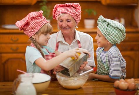 Il Nipote E La Nipote Baciano La Loro Nonna Nella Cucina Immagine Stock Immagine Di Passatempo