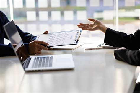 지원자는 이력서와 면접을 제출합니다 이력서를 들고 사업가는 사무실에서 일자리를 위해 인터뷰하고 있습니다 2명에 대한 스톡 사진