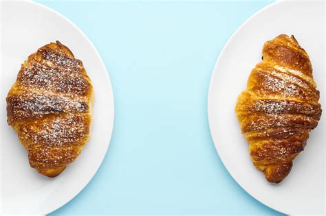 복사 공간이있는 파란색 배경에 갈색 지각을 가진 설탕 가루가있는 맛있는 크루아상 카페 광고의 개념 광고에 대한 스톡 사진 및