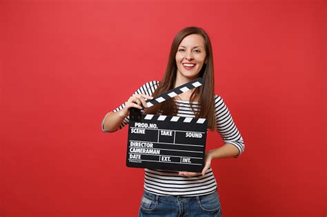 밝은 빨간색 배경에 고립 Clapperboard 만드는 고전적인 흑인 영화를 들고 줄무늬 옷에 매력적인 젊은 여자의 초상화 사람들이 진심으 감정 라이프 스타일 개념 복사