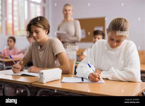 School Lesson Students Write Down Assignments While Sitting At Desks