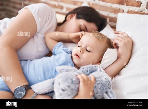 Mother And Son Sleeping On Bed Hugging Doll At Bedroom Stock Photo Alamy