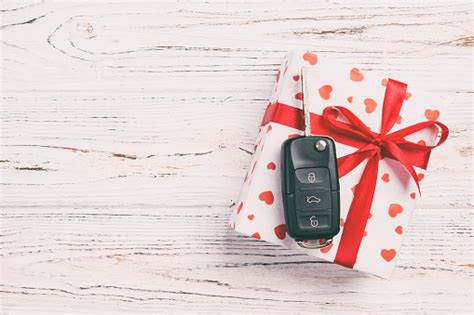 발렌타인 데이 또는 다른 휴일 수제 선물 빨간 마음 자동차 열쇠와 휴일 포장지에 선물 상자 복사 공간 디자인을위한 빈 공간 흰색 나무 테이블 상단보기에 상자 선물 개념에