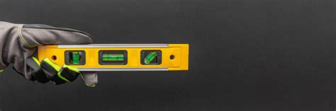 장갑을 낀 손은 검은색 배경에 노란색 건물 레벨을 담고 있습니다 인쇄용 엽서 또는 포스터 텍스트 장소 개념에 대한 스톡 사진 및 기타 이미지 Istock