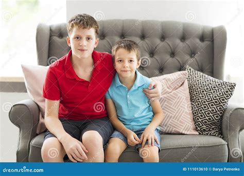 Older Brother on the Sofa Hugging Younger Brother Stock Photo - Image ...