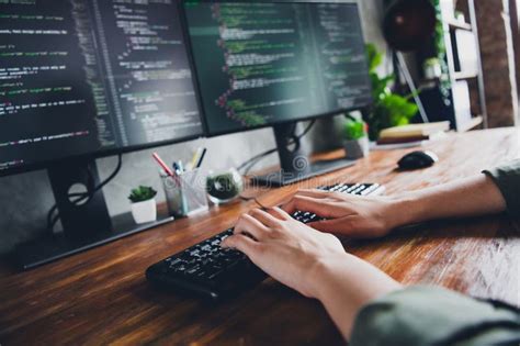 Young Female Programmer Working With Code On Dual Monitors In A Stylish Workspace Symbolizing