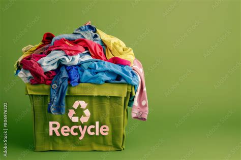 Vibrant Assortment Of Clothes Spills Out Of A Green Recycling Bin With