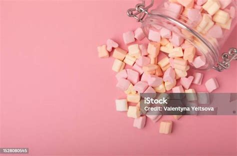 유리 그릇에 분홍색 배경에 마시멜로 하얀 마시멜로 플랫 레이 간식을위한 과자와 스낵 씹는 사탕 클로즈업 공간을 복사합니다 텍스트를위한 장소 겨울 음식 개념 개체 그룹에 대한