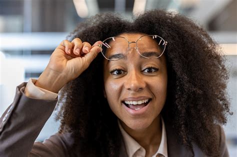 사무실에서 양복을 입은 젊고 행복한 아프리카 계 미국인 여성이 미소 짓고 카메라를보고 안경을 들고 있는 클로즈업 사진 25 29세에 대한 스톡 사진 및 기타 이미지 Istock