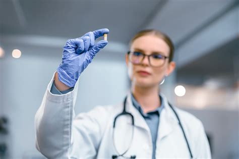 과학자 화학자 또는 의료 종사자가 치료법을 연구하거나 발견 한 후 치료법이나 백신 약을 소지하고 있습니다 실험실에서 실험 의약품이나 약물을 지지하는 혁신적인 여성 과학자에