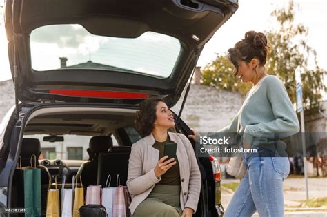 함께 쇼핑을 나간 후 주차장의 열린 차 트렁크 옆에서 놀고 있는 두 여자 친구 쇼핑에 대한 스톡 사진 및 기타 이미지 쇼핑 차 소매 소비자주의 Istock