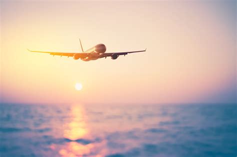 흐리게 열대 해변과 일몰 하늘 추상적 인 배경을 통해 비행 비행기 비즈니스 여름 휴가 및 여행 모험 개념의 공간을 복사합니다 빈티지 톤 필터 효과 색상 스타일입니다 0명에