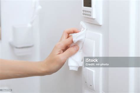 마이크로 화이버 천으로 스위치와 소켓을 청소합니다 여자 손 젖은 닦아 홈 룸 도어 링크를 청소 코로나 바이러스에 대한 병원 과 공공 장소에서 표면 예방을 살균 가정의 방에