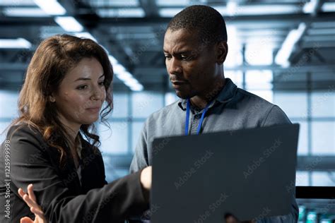 Employees In Data Center Using Laptop Integrating Green Technologies