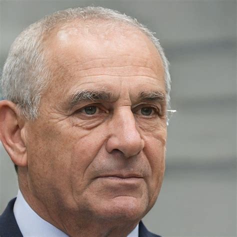 An Older Man In A Suit And Tie Looks Off To The Side While Wearing Glasses