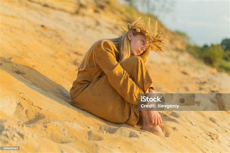 노란 드레스를 입은 금발의 여자가 강둑에 쉬고 있다 일몰 빛 여름날 긴 머리 모래 실의 8월에 대한 스톡 사진 및 기타 이미지 Istock