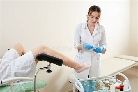 Ginecólogo Examinando A Un Paciente Sentado En Una Silla Ginecológica
