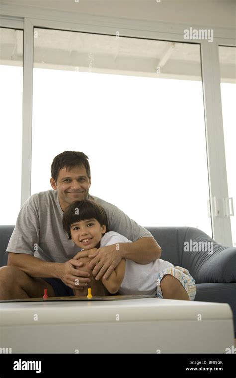 Mature Man Hugging His Son On A Couch Stock Photo Alamy