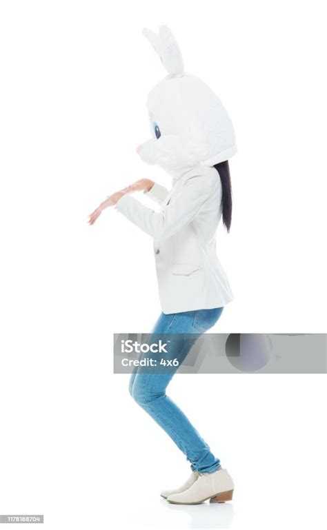 전체 길이 1인 정면 2029세 성인 미림 중남미 히스패닉 민족 여성 젊은 여성의 카메라를 보고 유머 시원한 자세 토끼 마스크를 착용 하는 흰색 배경 앞에서 건너뛰는 젊은