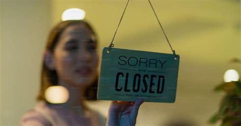 아시아 여성 커피 숍 바리 스타가 카페 문으로 걸어 가서 매달린 닫힌 표지판을 돌립니다 고객에게 서비스를 제공하기 위해 레스토랑을 준비하는 여성 웨이트리스 중소 기업