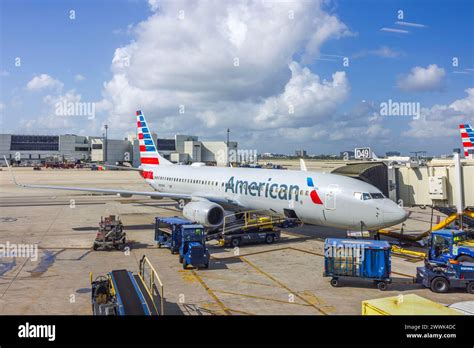 American Airlines Aircraft On The Tarmac During Baggage Loading Against A Blue Sky With White