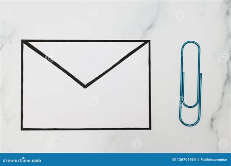 Funny Metaphor Of Inbox With Email Envelop And Attachment Clip On Real Life Desk Stock Photo