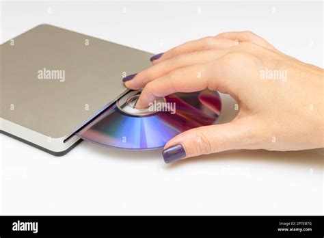 Woman Inserting A Laser Disc Into A Disk Drive The Hand Takes The Disk Out Of The Drive Hand