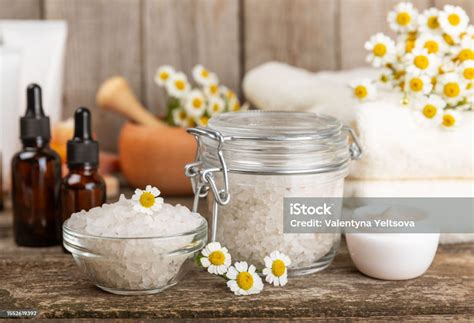 질감이 있는 배경에 허브 카모마일 추출물이 있는 해욕 소금 유리 항아리에 소금 바디 케어 화장품 천연 유기농 제품 약초 아름다움 개념입니다 텍스트를 위한 위치입니다 복사