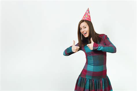 꽤 백인 젊은 여 자가 격자 무늬 드레스와 매력적인 미소로 생일 파티 모자 휴일 표시를 축 하 하는 광고에 대 한 흰색 배경 위에 고립 된 두 손 복사 공간에 최대 엄지