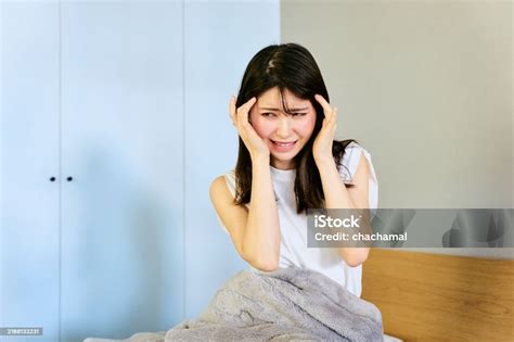 침실에서 잠자리에 들기 전에 옆방의 소음이나 스토커의 피해가 신경이 쓰이는 20대와 30대 독신 여성 20 29세에 대한 스톡 사진 및 기타 이미지 Istock