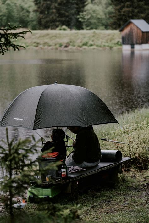 우산을 들고 빗속에서 벤치에 앉아있는 사람 사진 Unsplash의 무료 회색 이미지