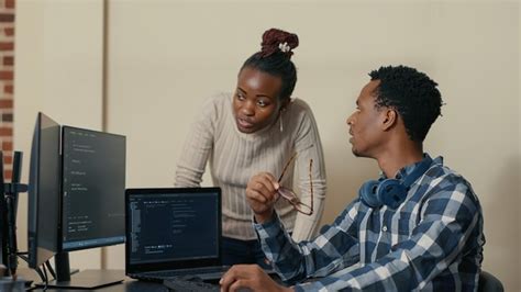 Premium Photo Database Developer Removing Glasses While Explaining Algorithm To Colleague
