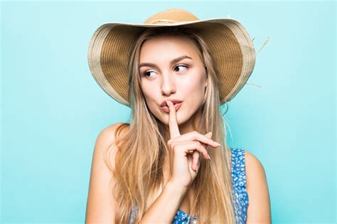 파란색 배경 위에 고립 된 비밀로 하 입술에 손가락을 보여주는 큰 밀 짚 모자를 쓰고 유럽 매력적인 여자의 초상화 근접 촬영 갈색에 대한 스톡 사진 및 기타 이미지 Istock