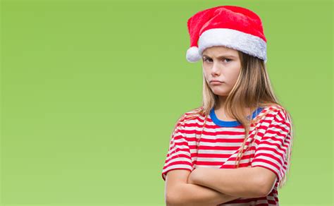 격리 된 배경 회의론 및 교차 팔과 얼굴에 긴장 Disapproving 식 크리스마스 모자를 쓰고 젊은 아름 다운 소녀 부정적인 사람입니다 감정에 대한 스톡 사진 및 기타