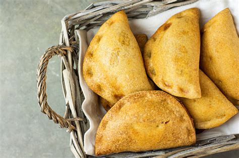 홈 구운 Empanadas 회전율 파이 피스 야채 치즈와 고리 버들 세공 바구니에 토마토 소스 작성 스페인 과자입니다 어두운