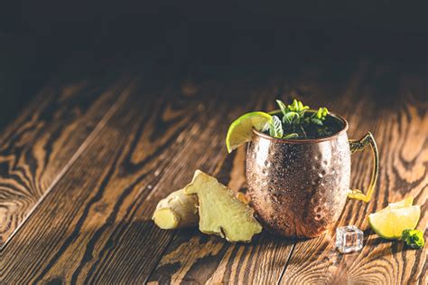 모스크바 노새 알코올 칵테일 구리 머그잔에 분쇄 된 얼음 민트와 레몬 민트 와 놀라운 백라이트와 민트 어두운 나무 테이블 복사 공간 0명에 대한 스톡 사진 및 기타 이미지