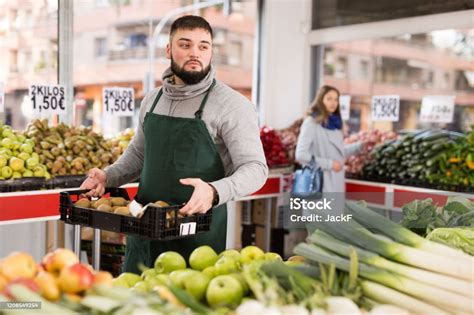 식료품 점에서 키위와 상자를 보여주는 긍정적 인 남자 직원 식료품상에 대한 스톡 사진 및 기타 이미지 식료품상 과일 나름 Istock