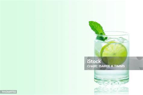 얼음 조각을 곁들인 진토닉 라임 슬라이스와 민트로 장식 흰색 배경에 격리되어 있습니다 재미있는 여름 음료와 파티 개념 박하