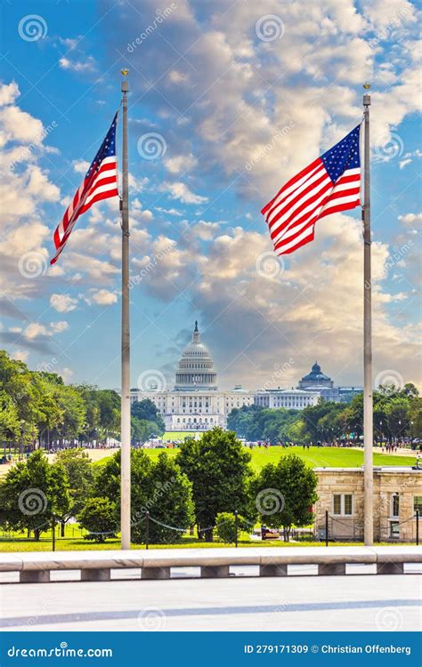 The United States Capitol Building With Us Flags In Foreground