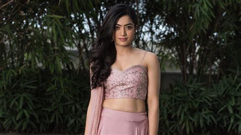 Beautiful Rashmika Mandanna Is Wearing Peach Color Dress Standing In Green Trees Background HD