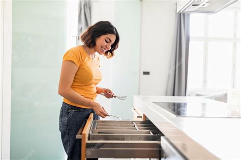 premium photo smiling middle eastern female tidying up cutlery in