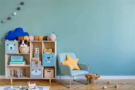 나무 캐비닛 민트 안락 의자 천연 테디 베어 및 봉제 인형 장난감이있는 스칸디나비아 보육실 유칼립투스 벽 아기 액세서리 및 장난감놀이방의 귀여운 현대적인 인테리어 공간을