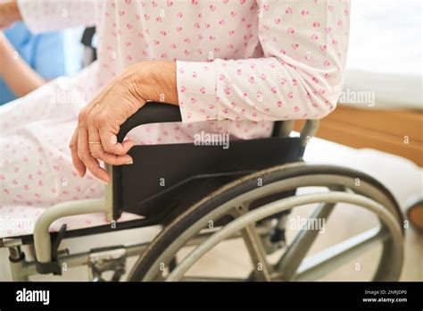 Midsection Of Elderly Woman Sitting In Wheelchair At Rehabilitation