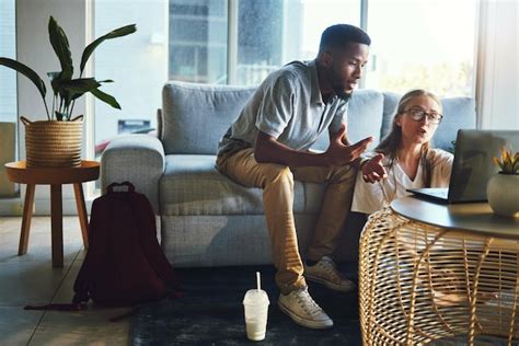 Verbinden Sie Laptop und Schulden während Sie auf der Couch im Wohnzimmer über Remote