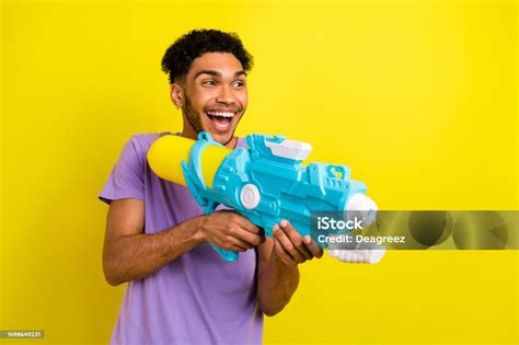 평온한 긍정적 인 사람의 손은 물총 권총을 들고 노란색 배경에 고립 된 빈 공간을 보입니다 청년 남자에 대한 스톡 사진 및 기타 이미지 Istock