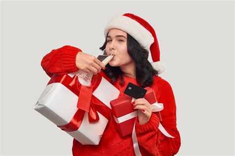 빨간 스웨터와 산타 모자에 갈색 머리 소녀는 선물 상자 은행 카드와 샴페인의 유리를 들고 12월에 대한 스톡 사진 및 기타 이미지 12월 갈색 머리 겨울 Istock