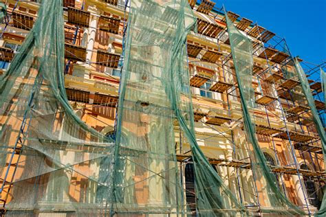 building structure with netting shade and scaffolding covered stock