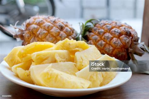 절단 신선한 파인애플과 파인애플 껍질 오래 된 나무 배경에 흰색 접시에 아시아 스타일 열 대 과일 개념입니다 가시에 대한 스톡